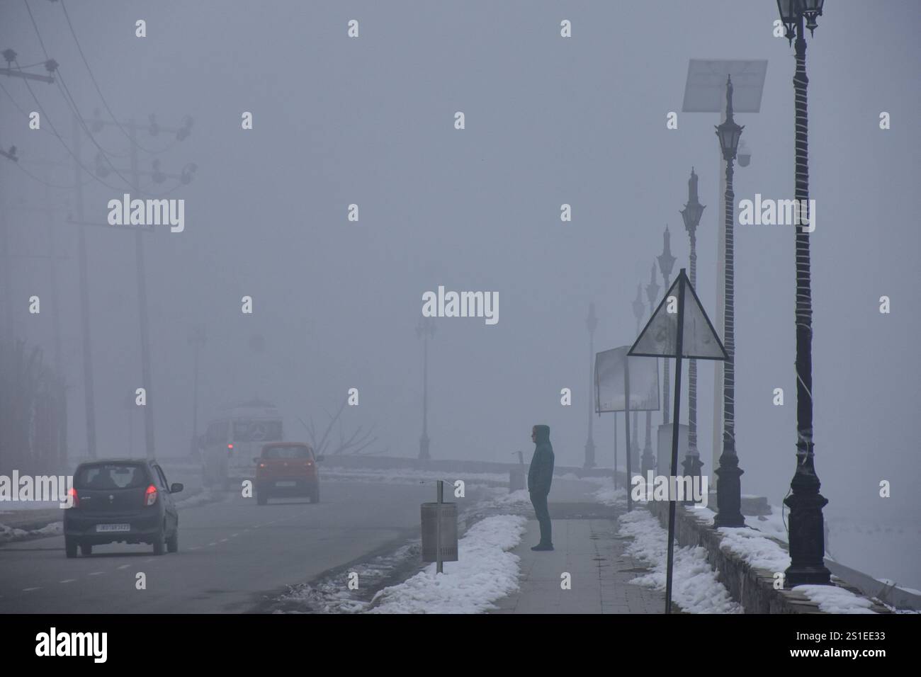 Srinagar, India. 3rd Jan, 2025. A commuter waits for the passenger bus ...