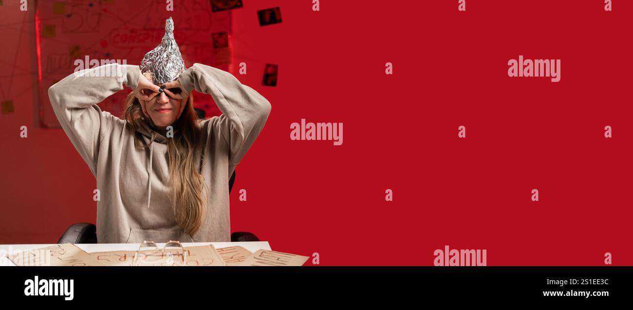Woman wearing glasses in foil hat showing eyeglasses gesture with ...