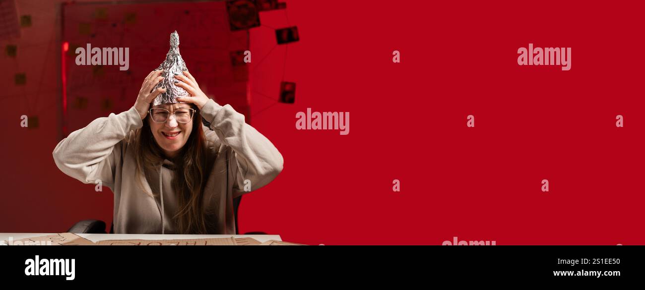 Female conspiracy theorist in protective foil cap and glasses debunks ...