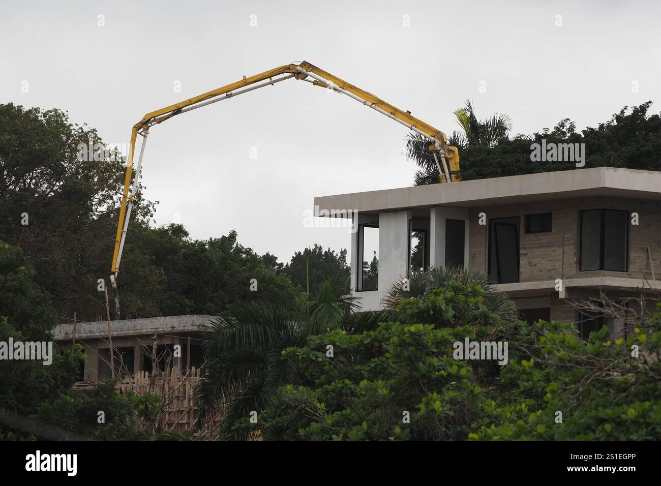 Construction activity with a concrete pump extending over a new ...