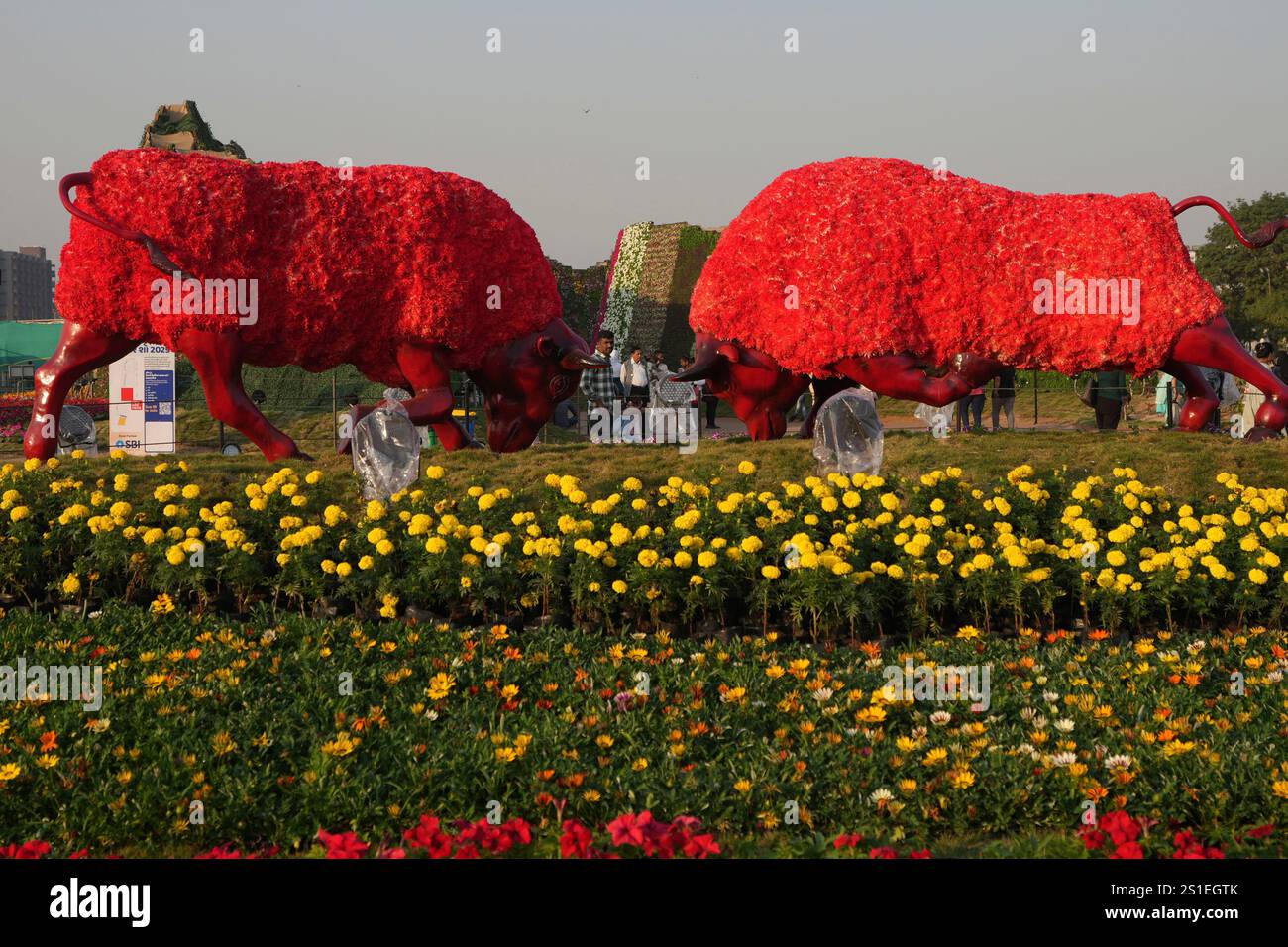 Visitors look at a sculpture of fighting bulls made by flowers at a ...