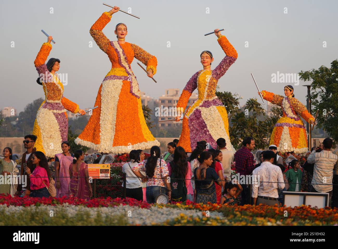 Visitors look at a sculpture of Garba performance, made by flowers at a ...