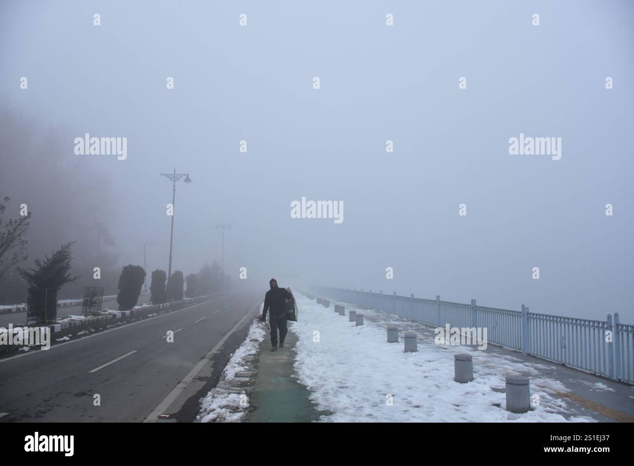 Srinagar, India. 03rd Jan, 2025. A sweeper walks through the street ...