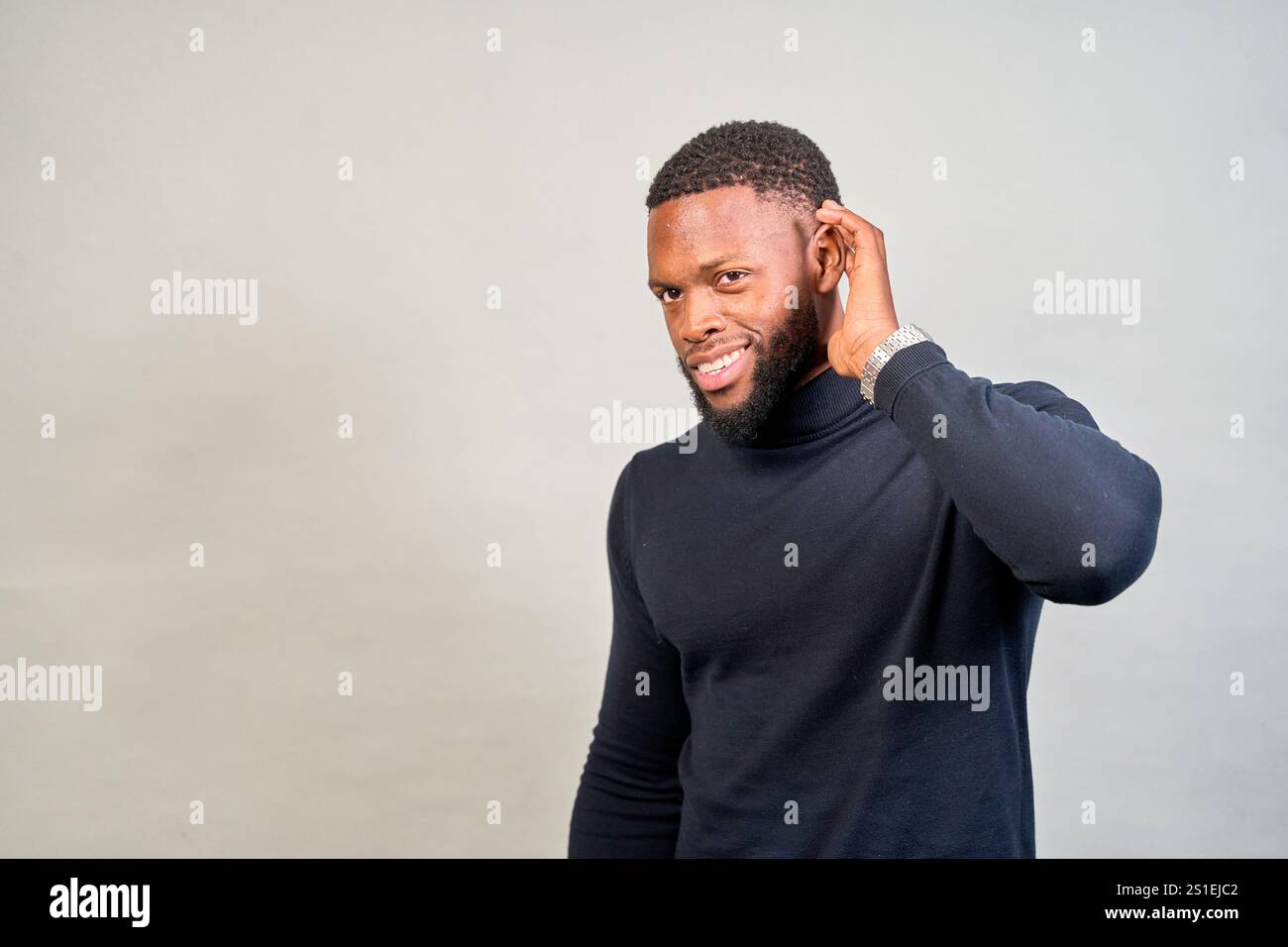 Studio portrait of a young businessman holding his hand to his ear ...