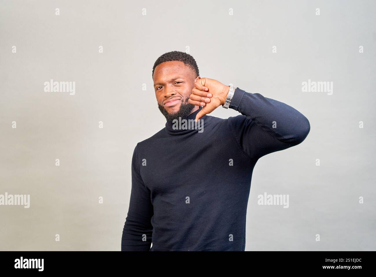 Young man making thumbs down hand sign gesture, expressing disapproval ...
