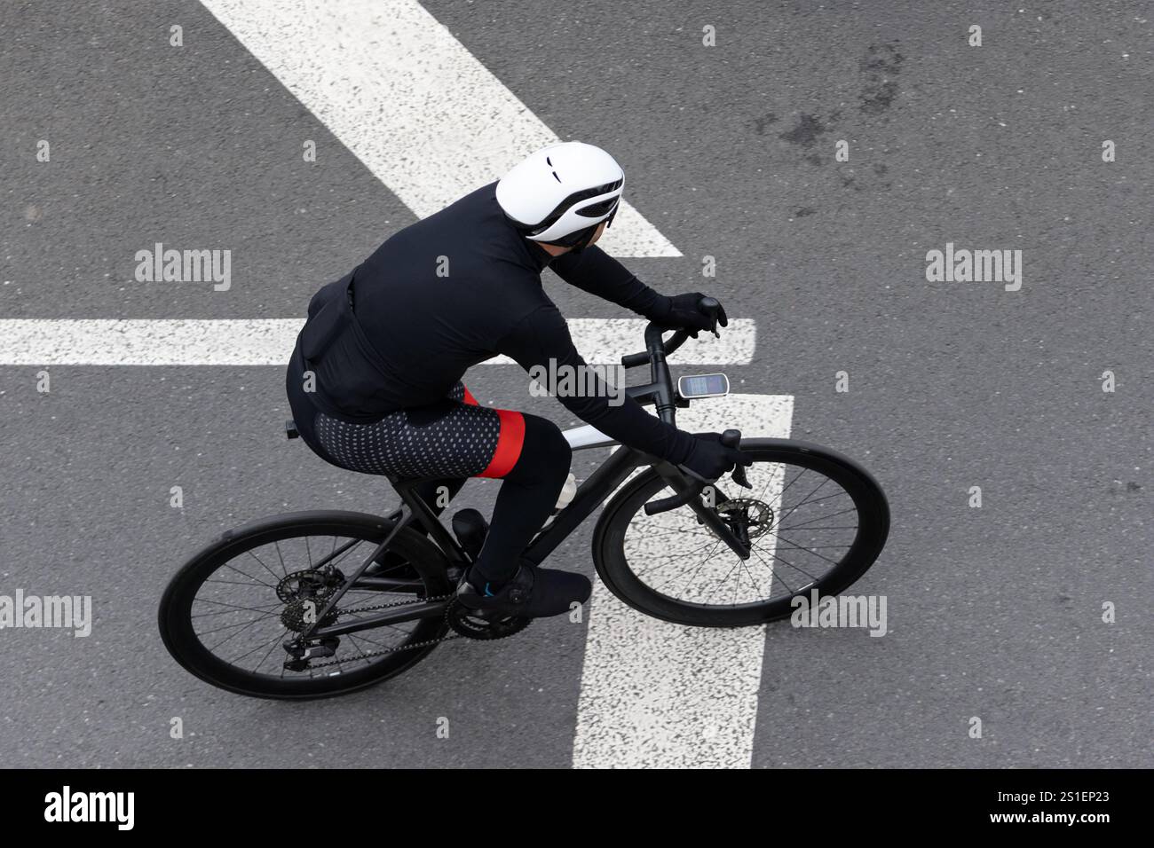 Cyclist wearing cycling clothing riding a high-end road bike on asphalt ...