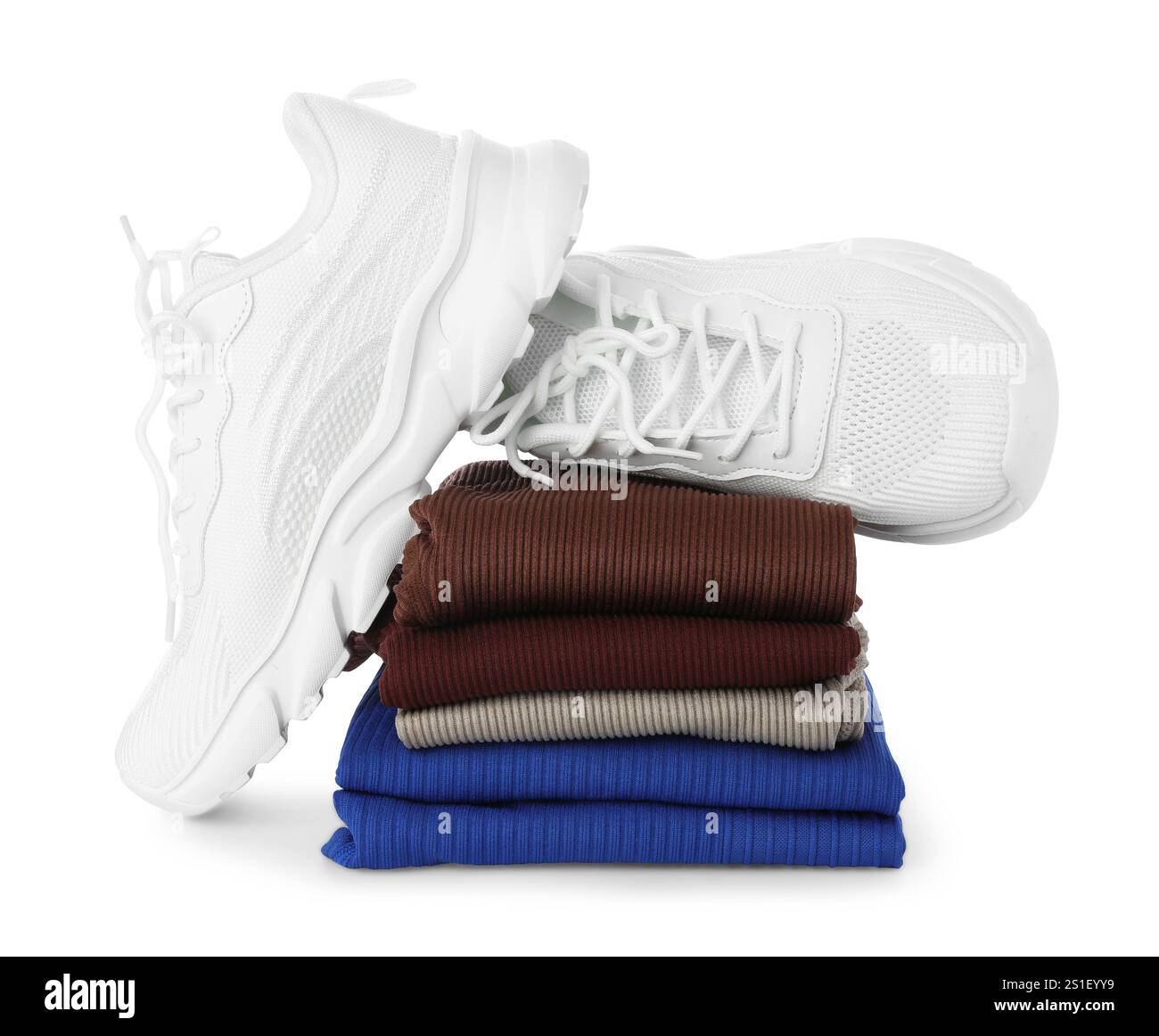 Stylish sneakers on stack of folded sportswear isolated on white Stock ...