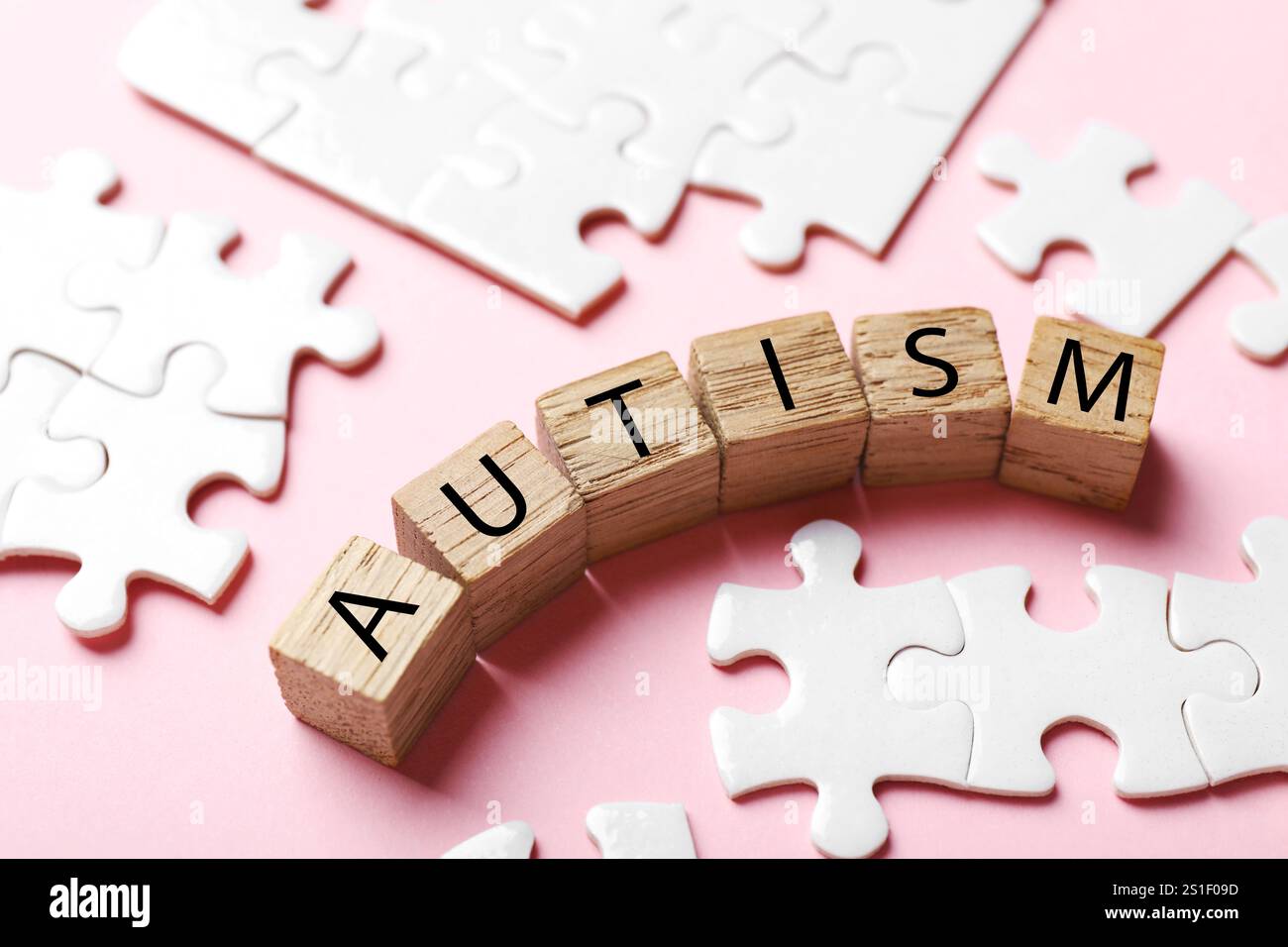 Word Autism made with wooden cubes and puzzle pieces on pink background ...