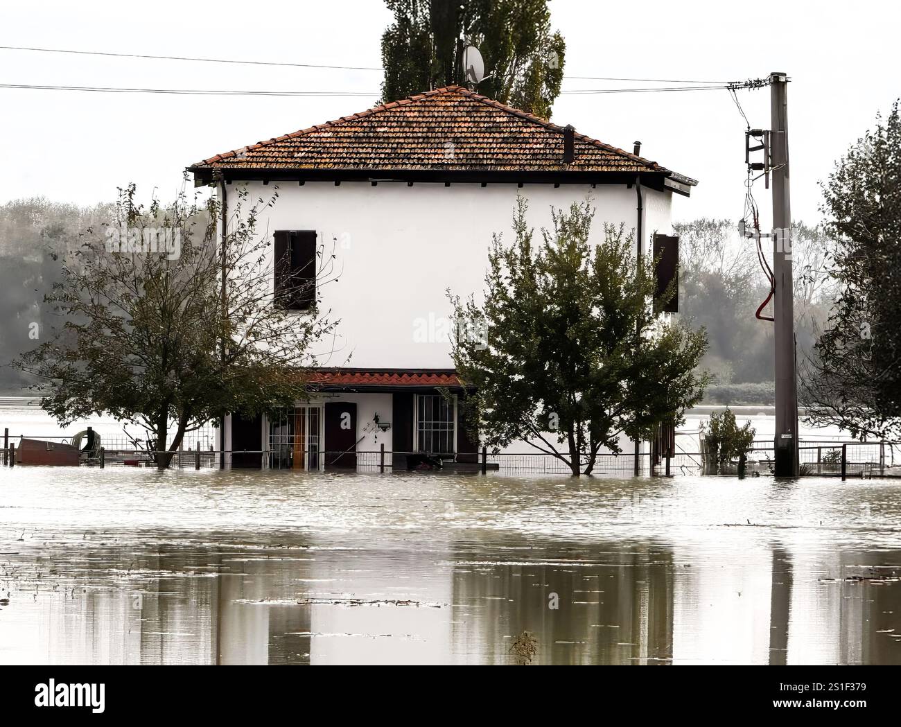Flooded house surrounded by rising water in a rural area. Severe ...