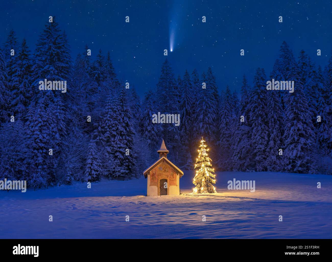 Illuminated Christmas tree with chapel at night, winter landscape ...