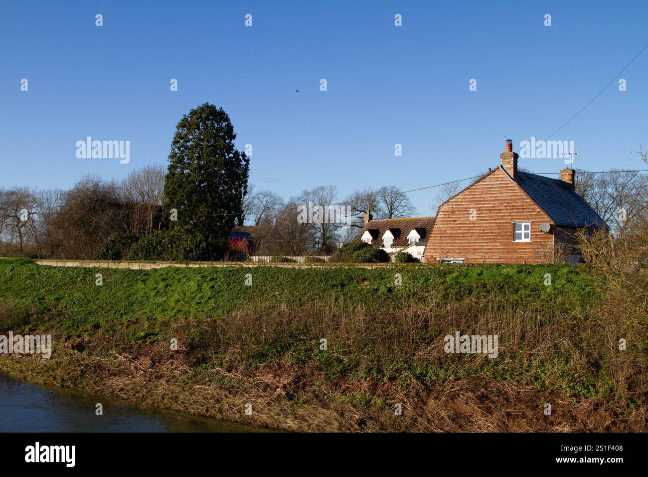 House with a Dutch barn style roof, on the banks of the river Delph on ...
