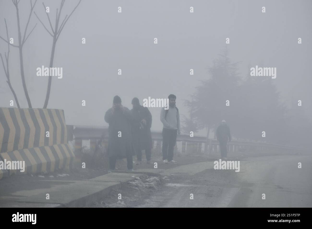 People walking through the fog due to freezing cold temperatures. Thick ...