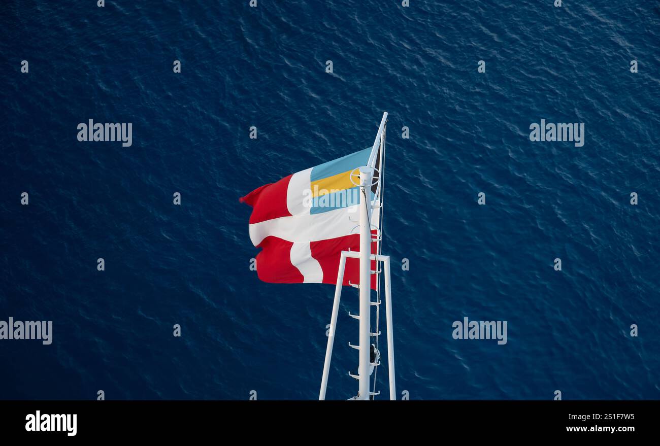 A vibrant flag waves proudly against the deep blue of the open sea, a ...