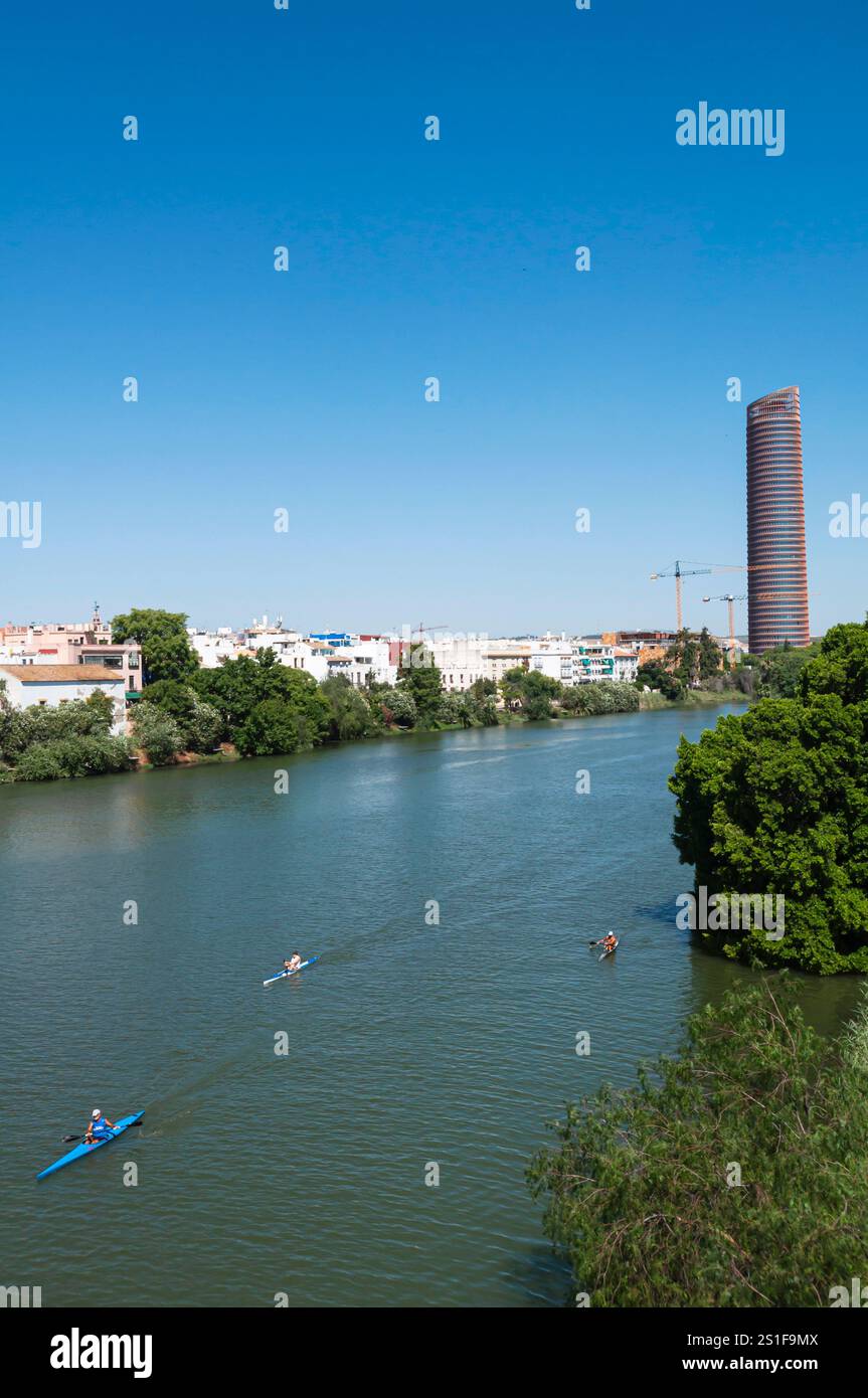 Guadalquiver river in summer view from the bridge, Sevilla Tower in the ...