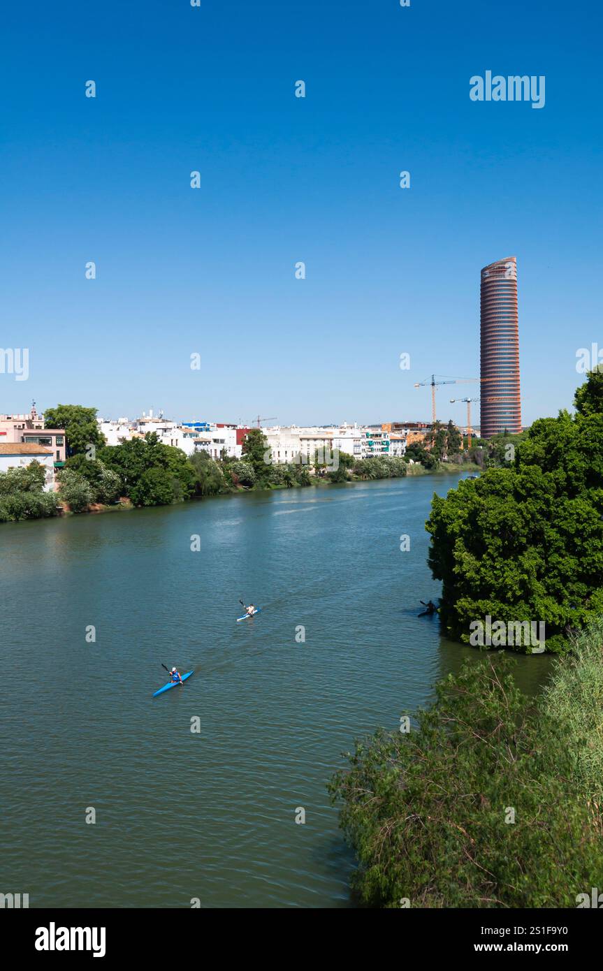 Guadalquiver river in summer view from the bridge, Sevilla Tower in the ...