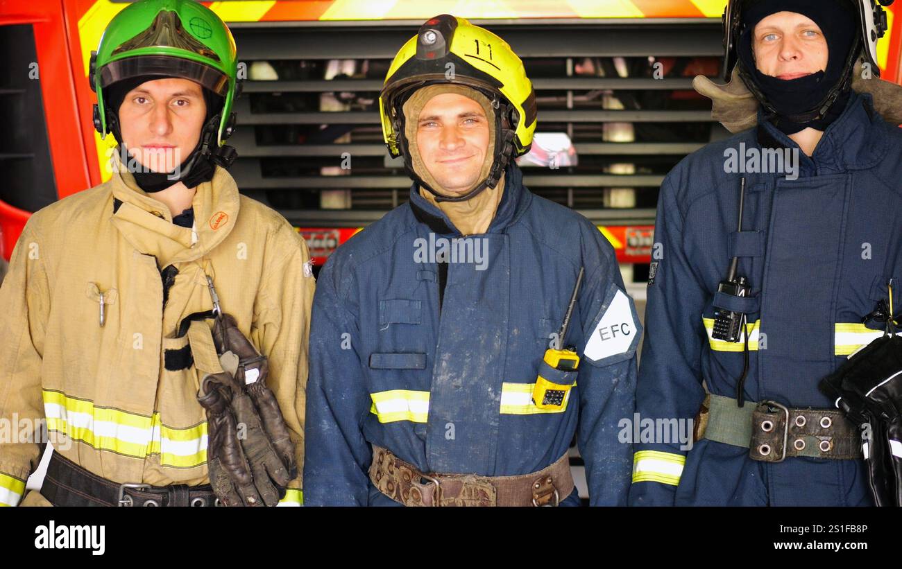 Portrait of young happy fireguards in protective uniforms against ...