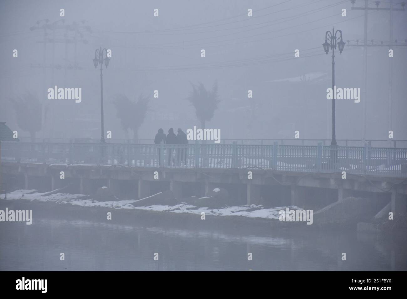 Srinagar, India. 3rd Jan, 2025. Commuters walk through the street ...