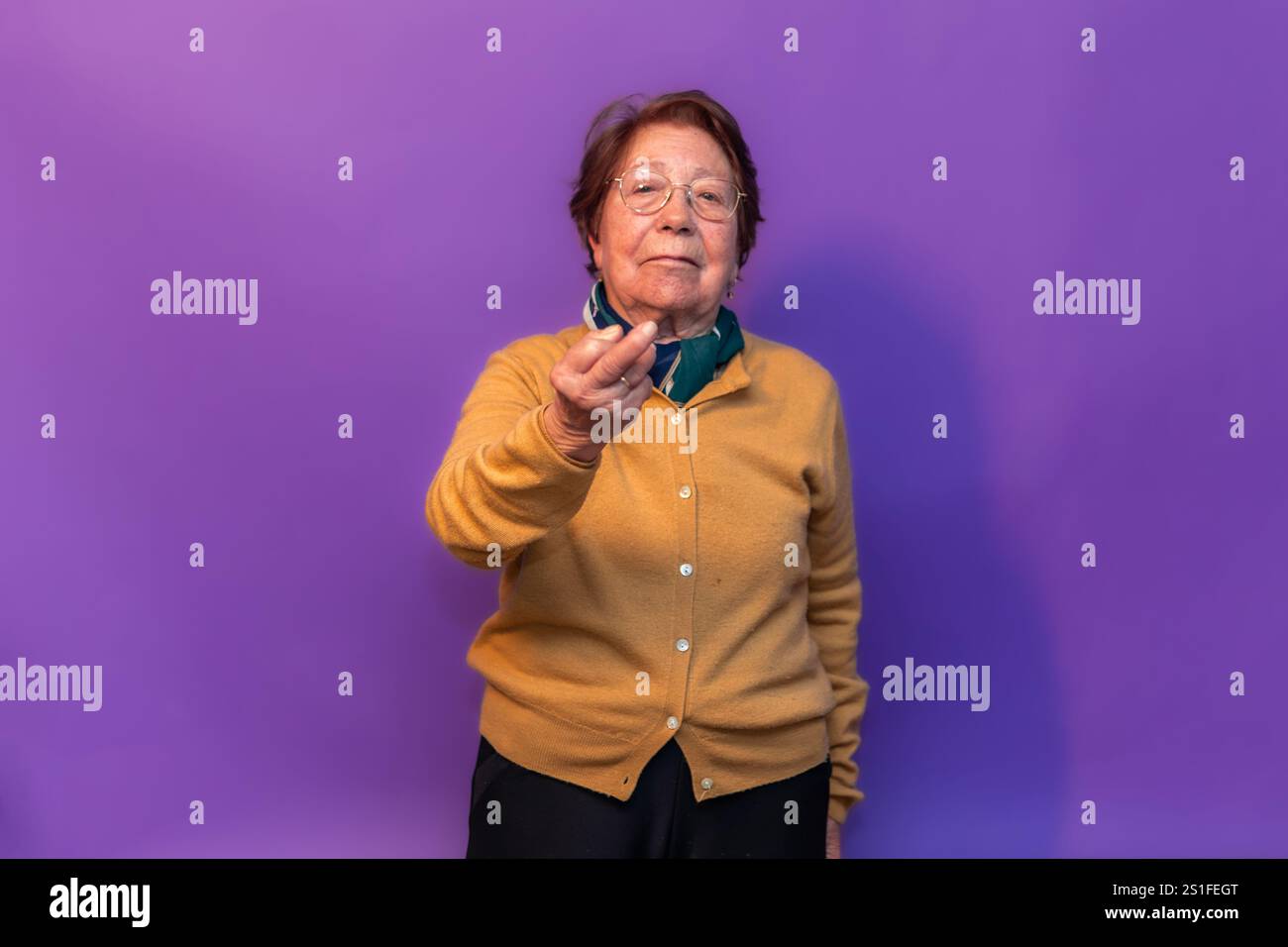 Elderly professor with glasses and mustard-colored cardigan making come ...
