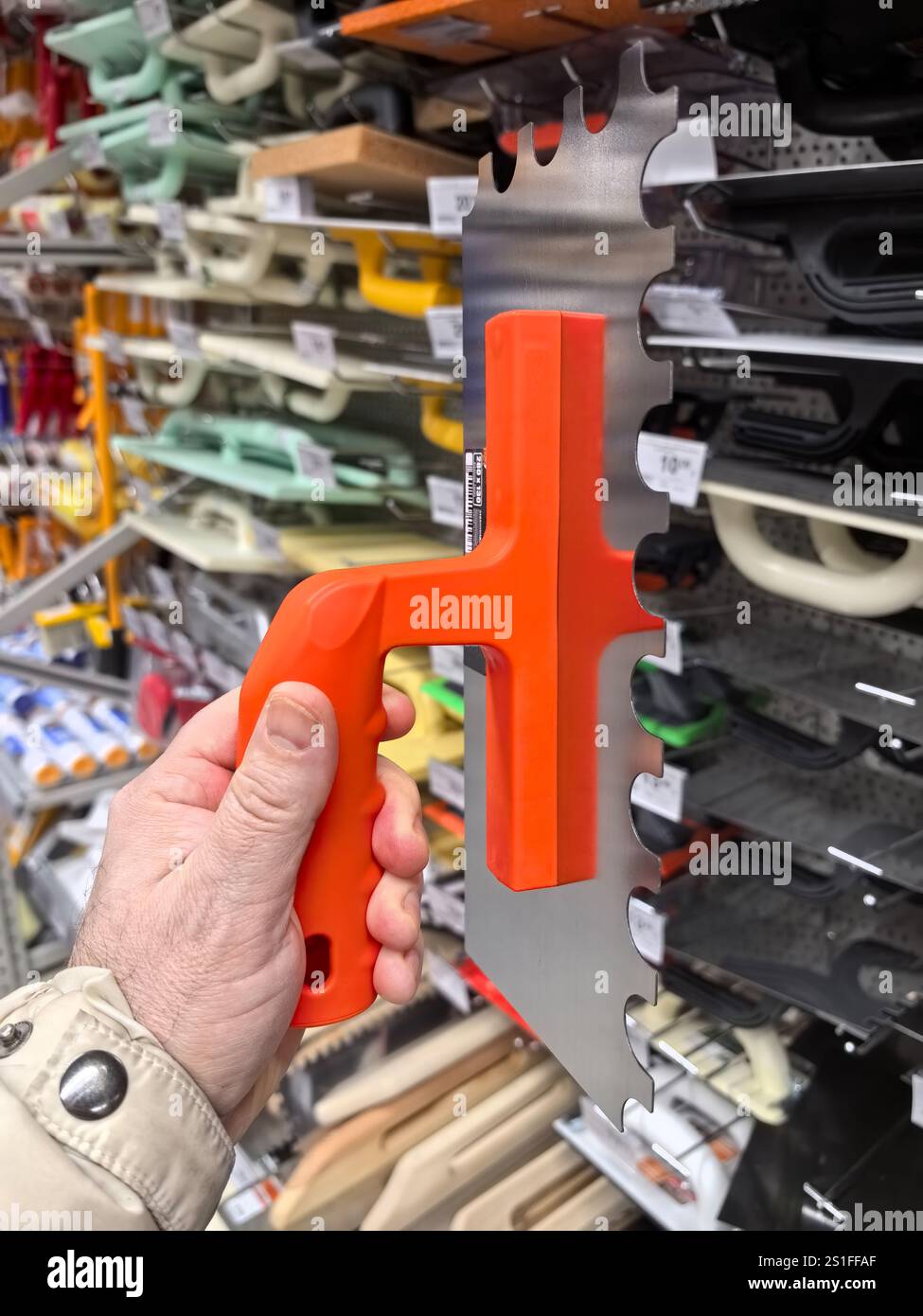 A person holds a uniquely designed tool featuring a bright orange ...