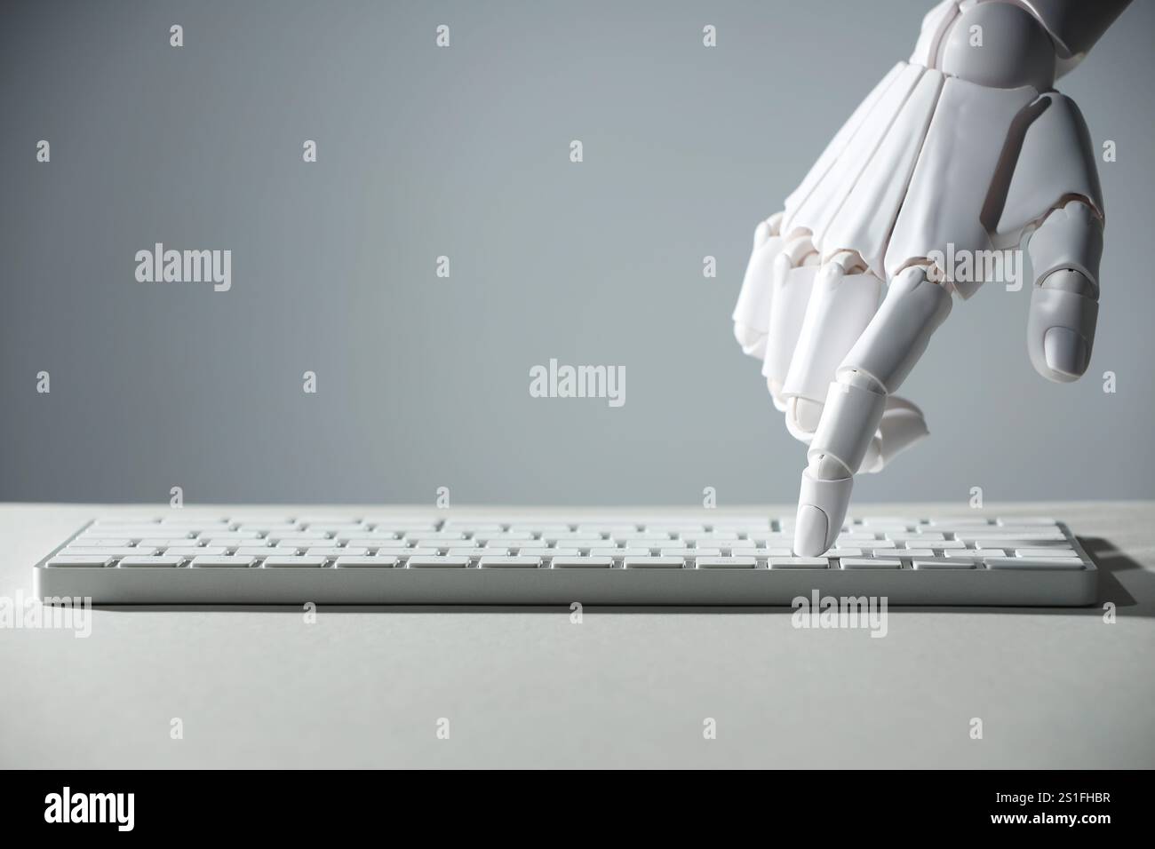 Artificial intelligence. Robot hand using keyboard at light table ...