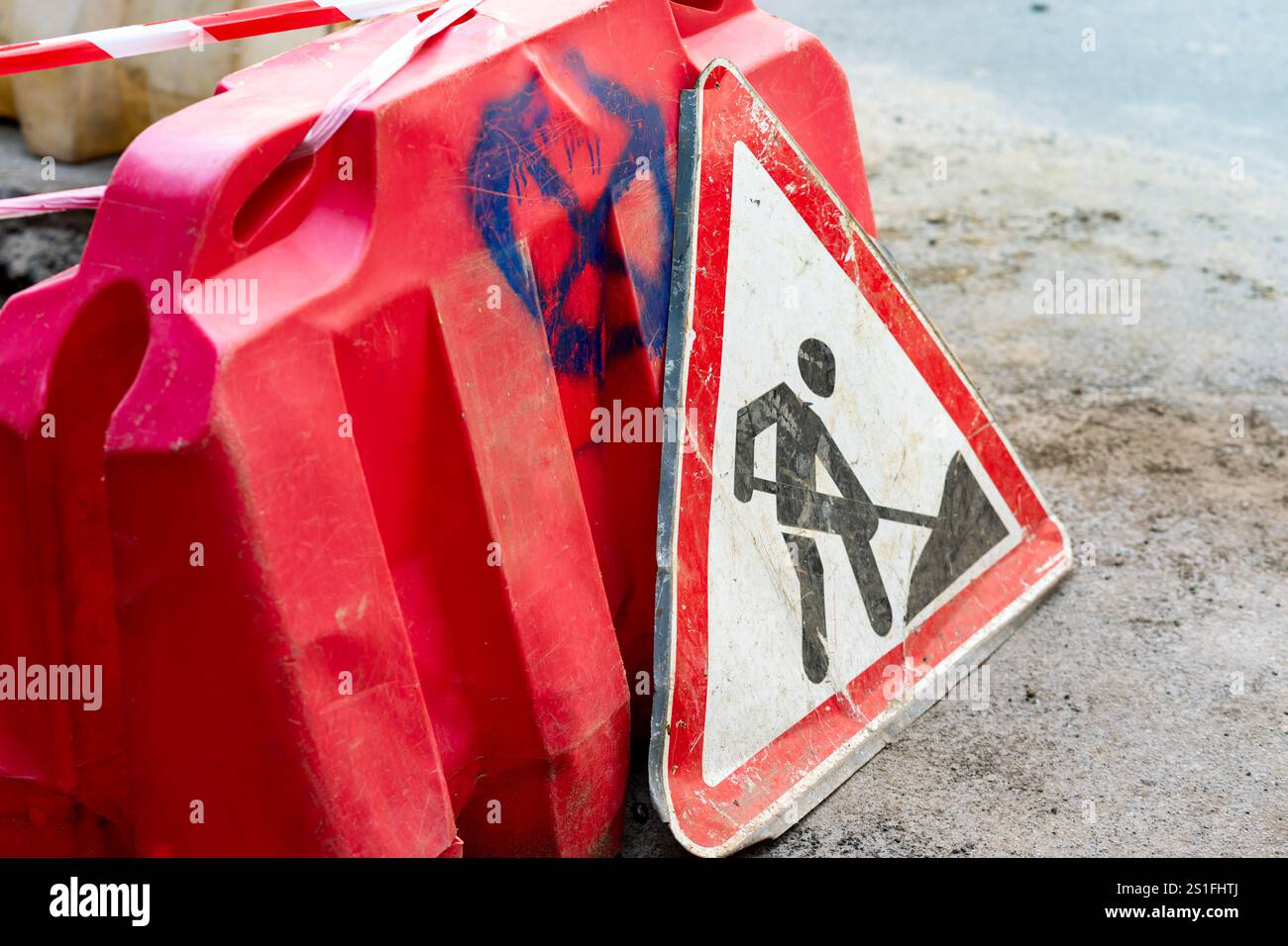 Bright red barriers and warning signs indicate ongoing construction ...