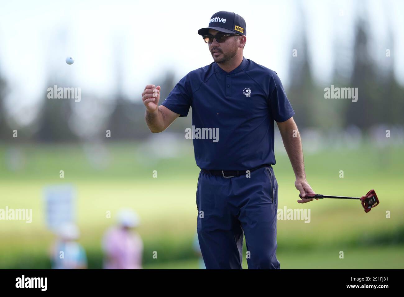 Jason Day, of Australia, flips his ball to his caddie at the second ...