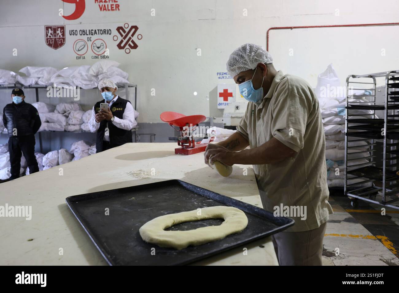 A prisoner works with the dough to make traditional king cakes, or ...