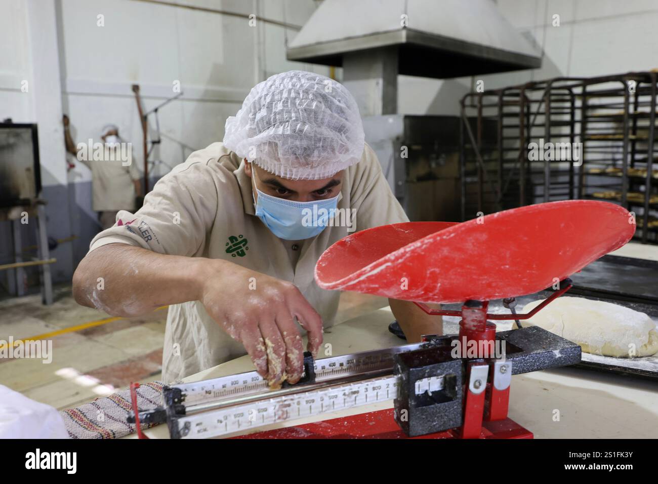 A prisoner weighs ingredients to make traditional king cakes, or ...