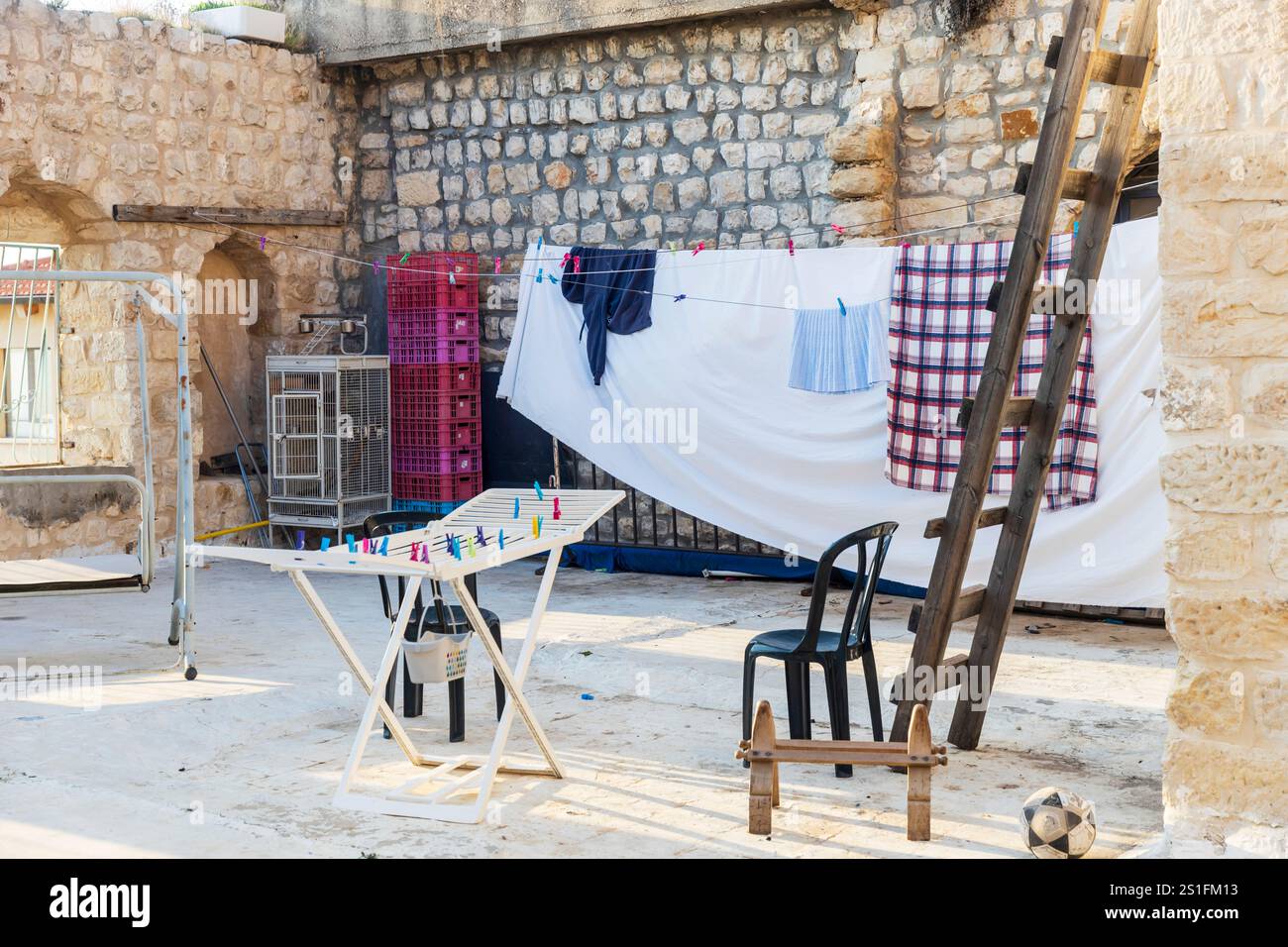 An inner courtyard of a house with a clothes dryer. Laundry hangs on ...