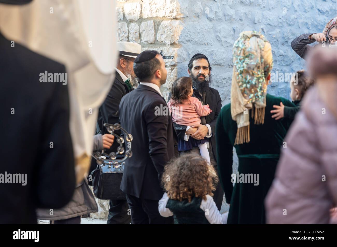 Tzfat, Israel - January 2, 2025, a man in a kippah, a Haredi, holds his ...