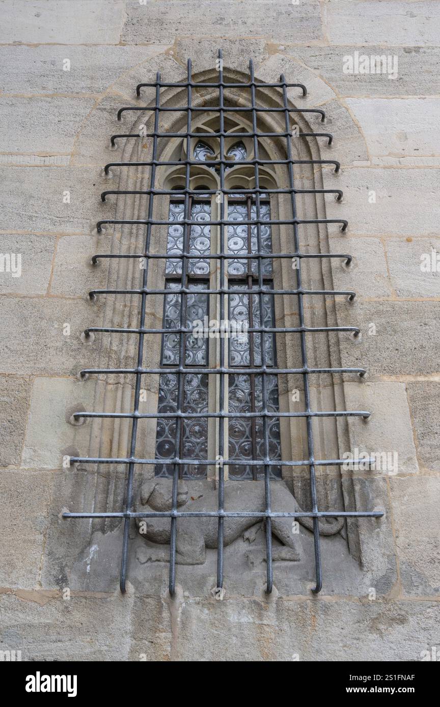 Pointed arch window with iron grating with a dog sculpture, late Gothic ...