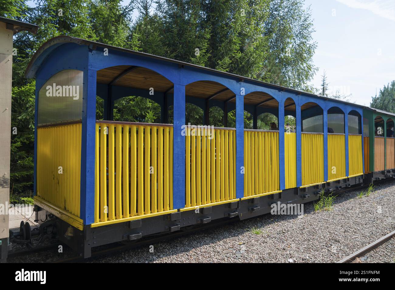 Blue and yellow wagon on tracks in a quiet forest environment, Wigry ...