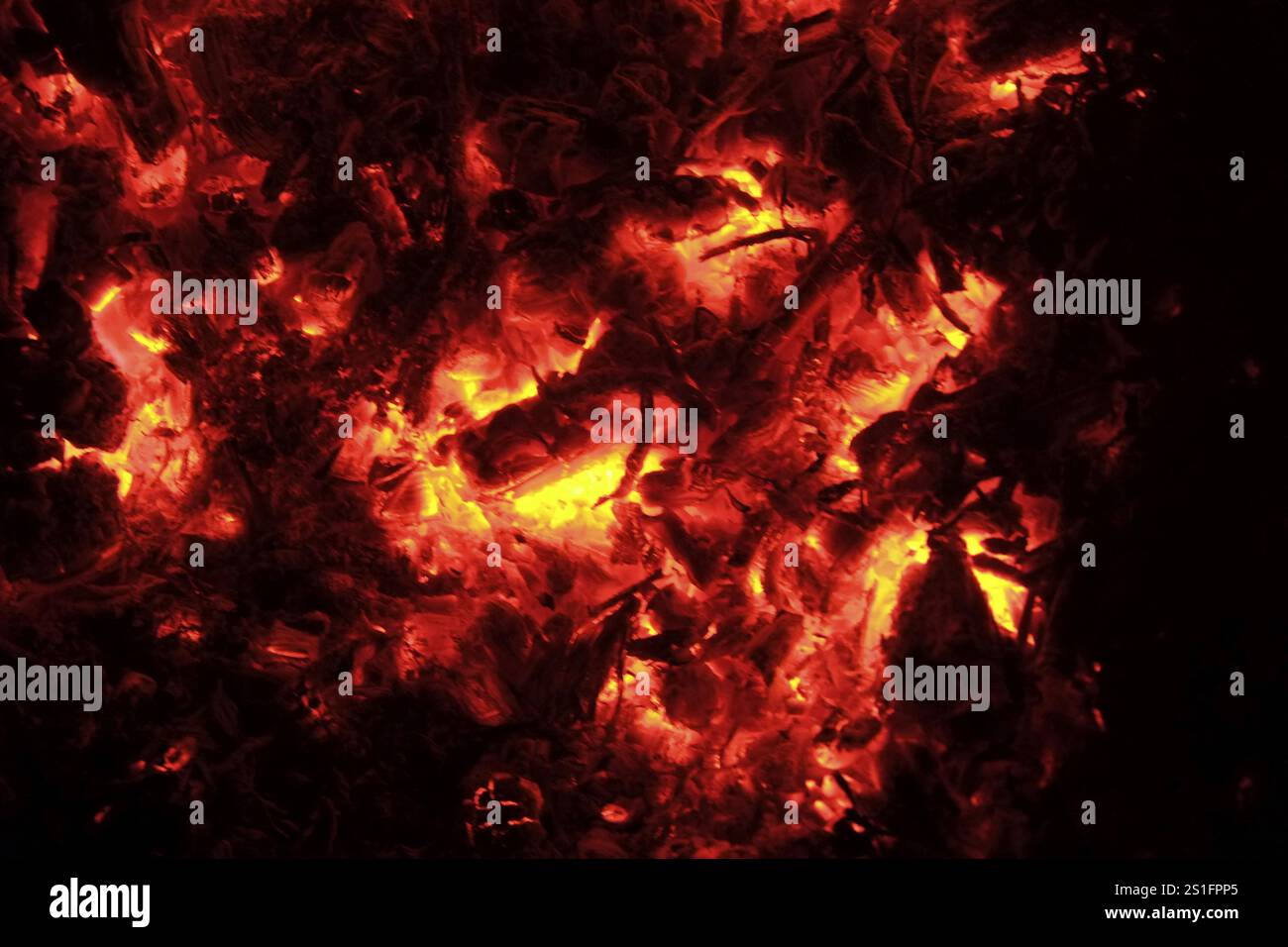 Red glowing remains of a burnt wood fire. From above, landscape format ...