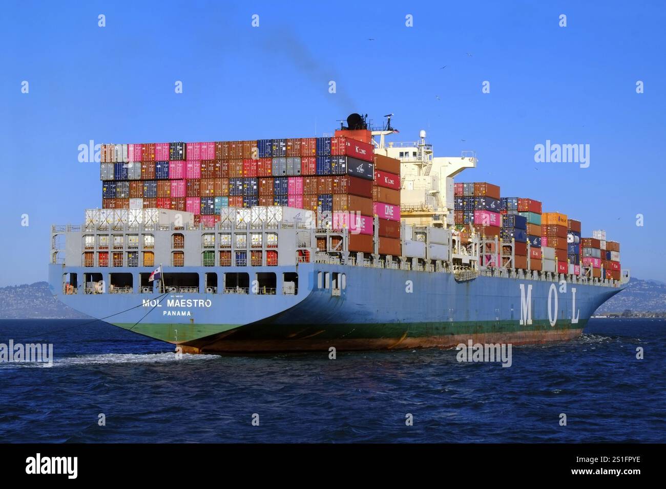 Container ship enters San Francisco Bay at a slow speed in bright ...