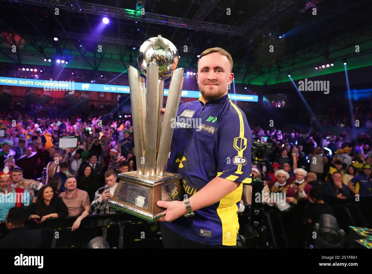Luke Littler of England holds the trophy after winning the final ...