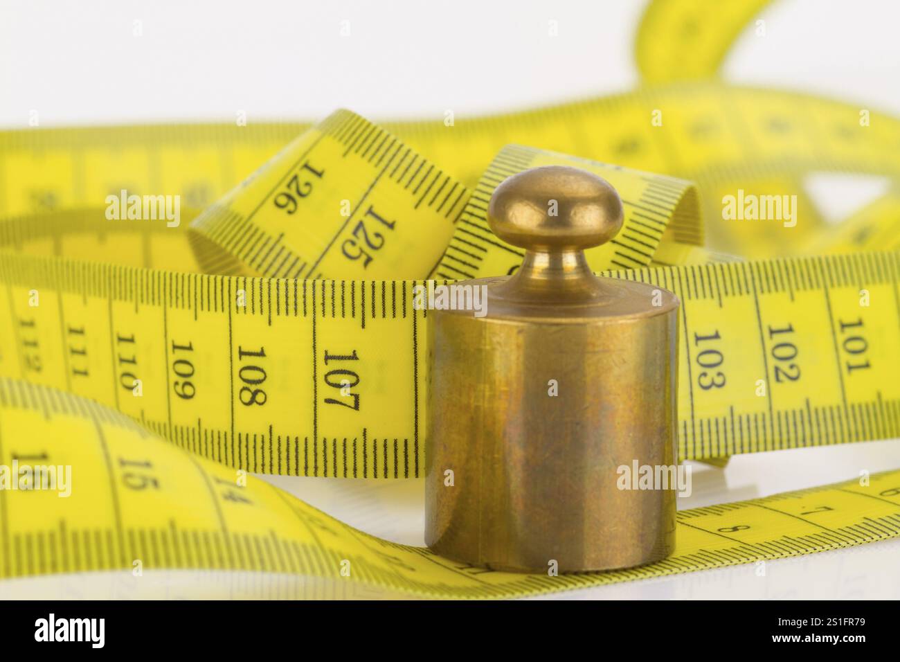 Brass weight with tape measure in detail Stock Photo - Alamy