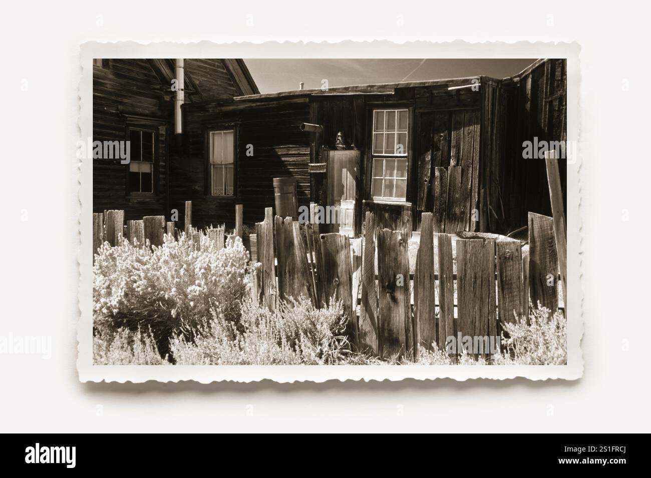 Half-height fence made of different boards, behind it a typical wooden ...