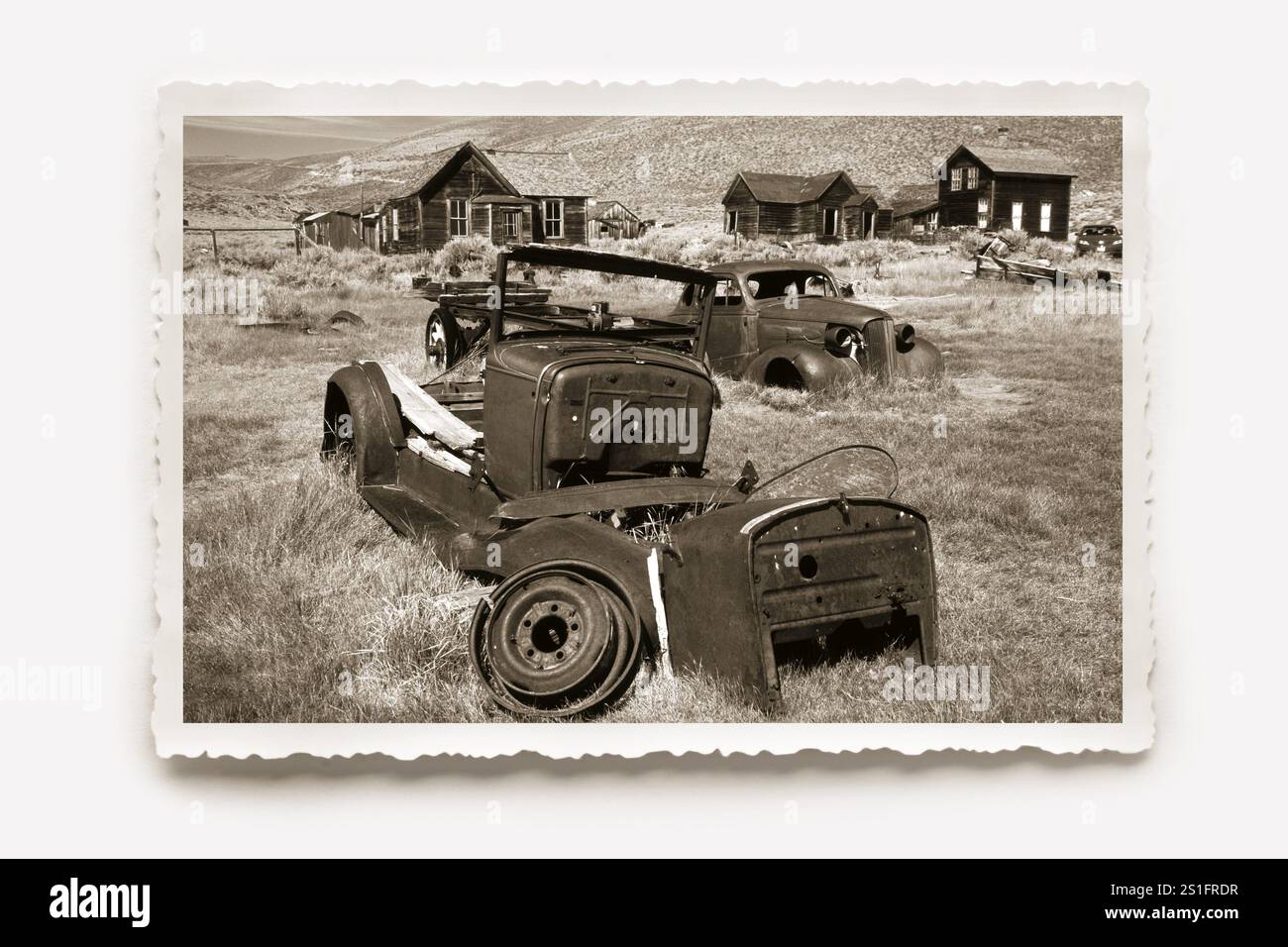 Rusting old car wrecks in front of wooden houses in the former gold ...