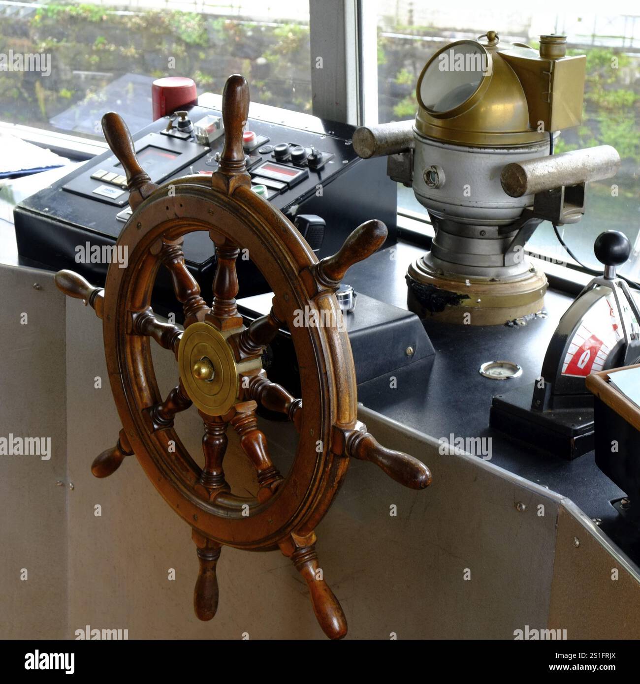Command bridge of a small excursion steamer with upright steering wheel ...