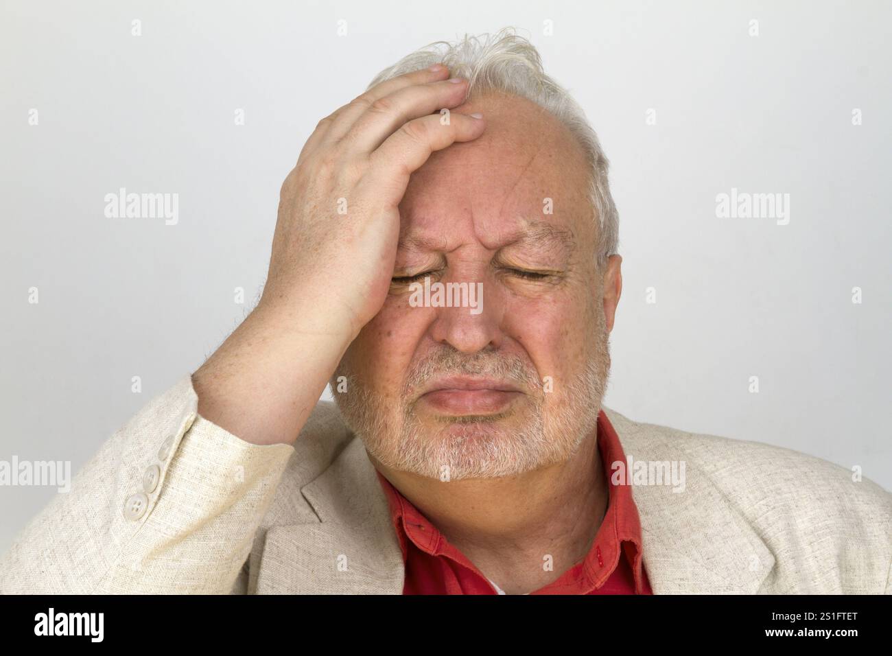 Desperate senior holds hand to forehead - on light-coloured background ...