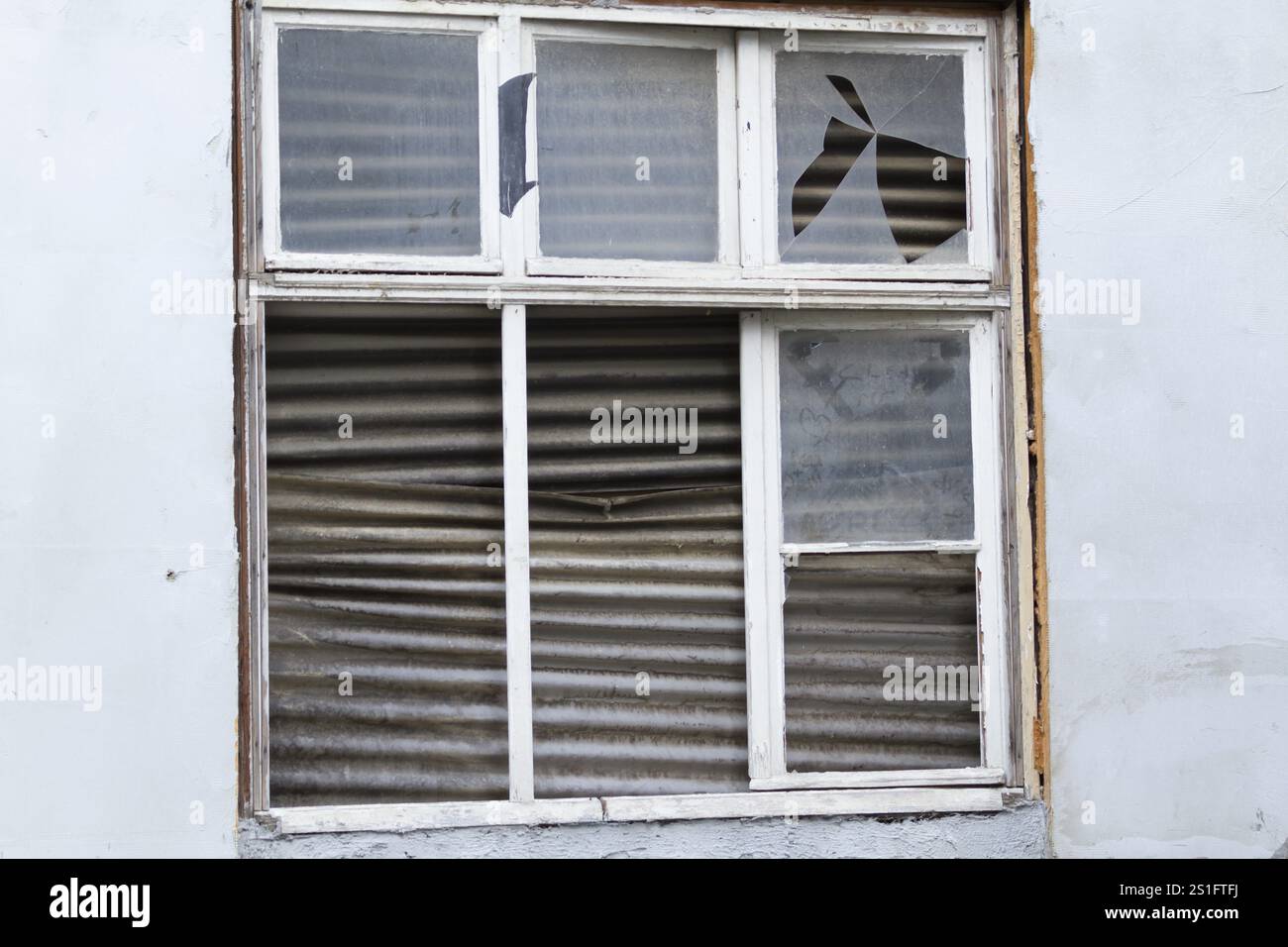 Old dilapidated window covered with corrugated cardboard from the ...