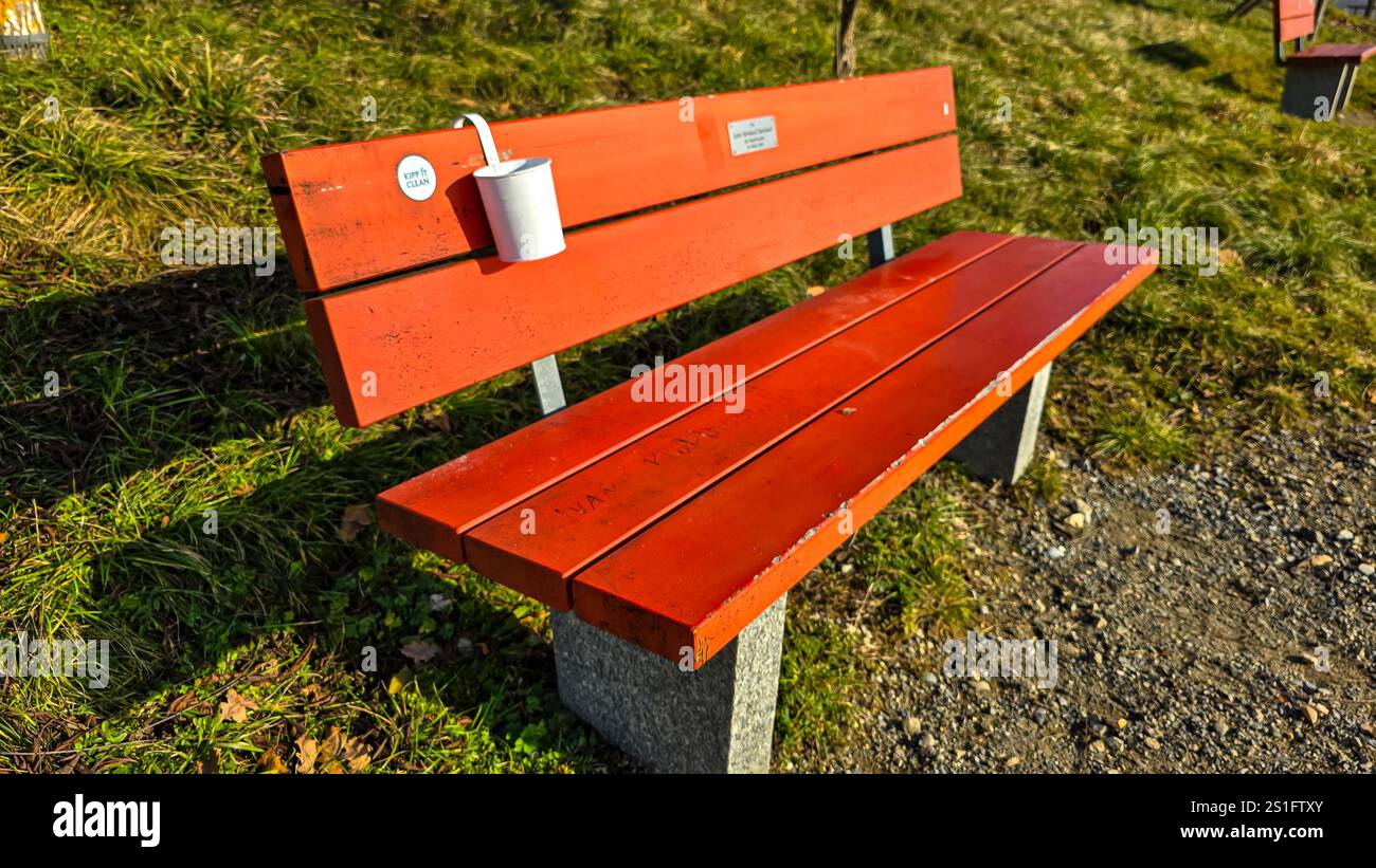 The red bench in the recreation area with the trash for the cigarette and inscription Kipp it ...