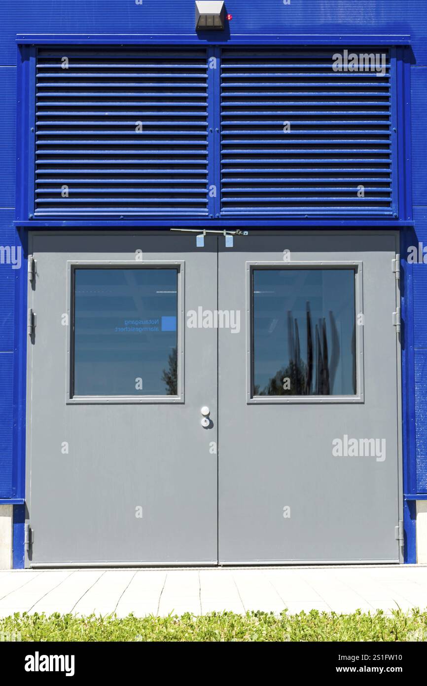 Locked metal door with window on an industrial building Stock Photo - Alamy