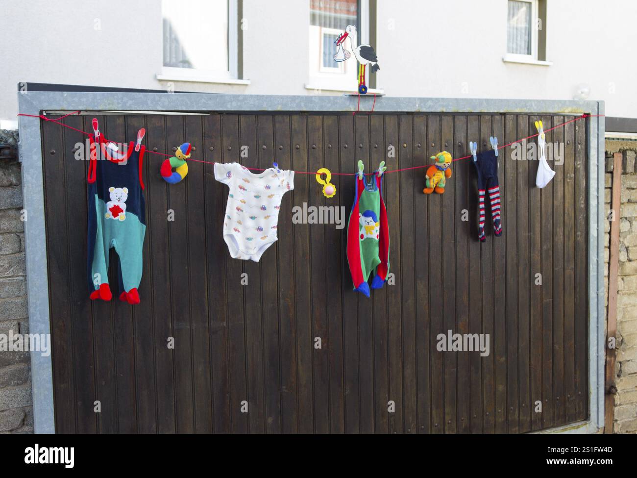 Washing line with children's clothes in front of the yard gate Stock ...