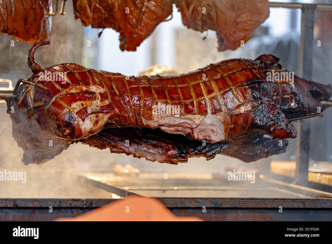 Cook's pig on a spit in the smoke over hot coals. Outdoor grill Stock ...