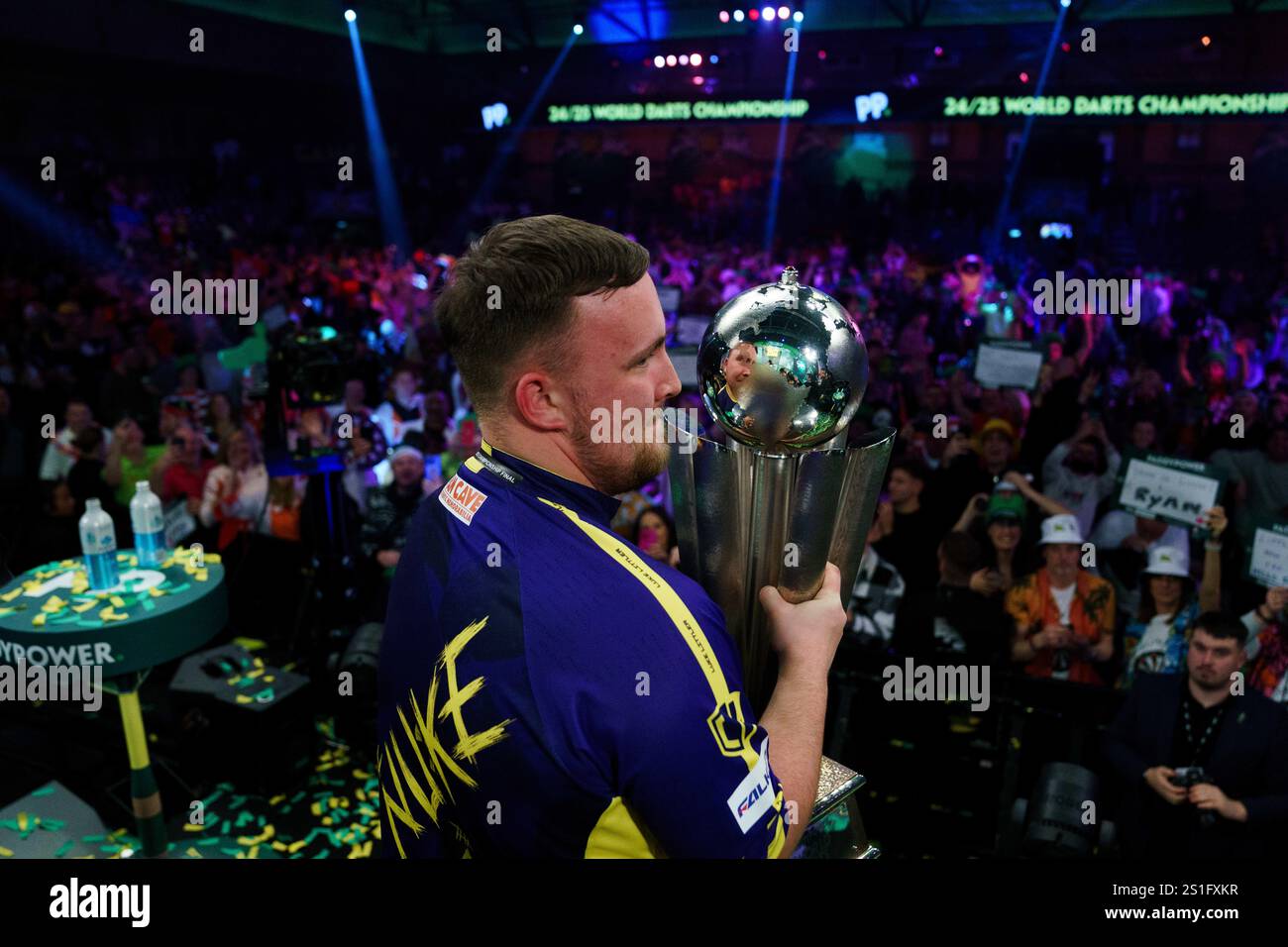 Luke Littler lifting the Paddy Power World Darts Championship trophy ...