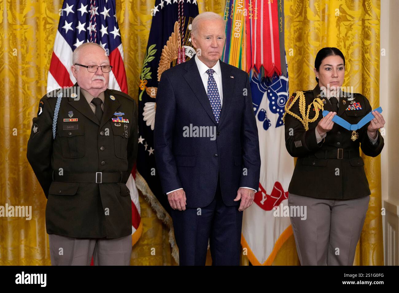 President Joe Biden, center, listens to the citation before presenting ...