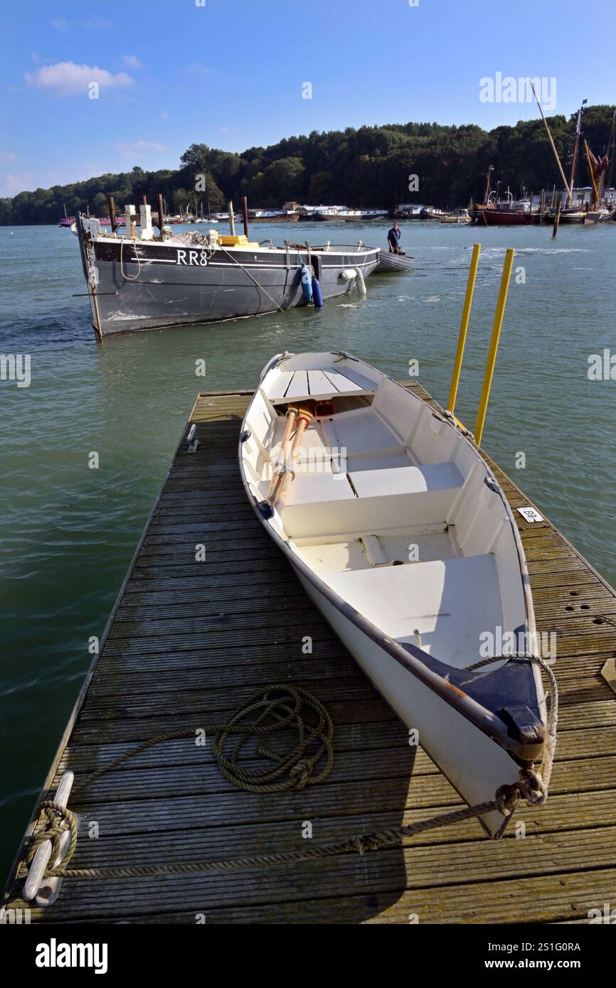vintage boat hull being moved past dinghy resting on pontoon, river ...