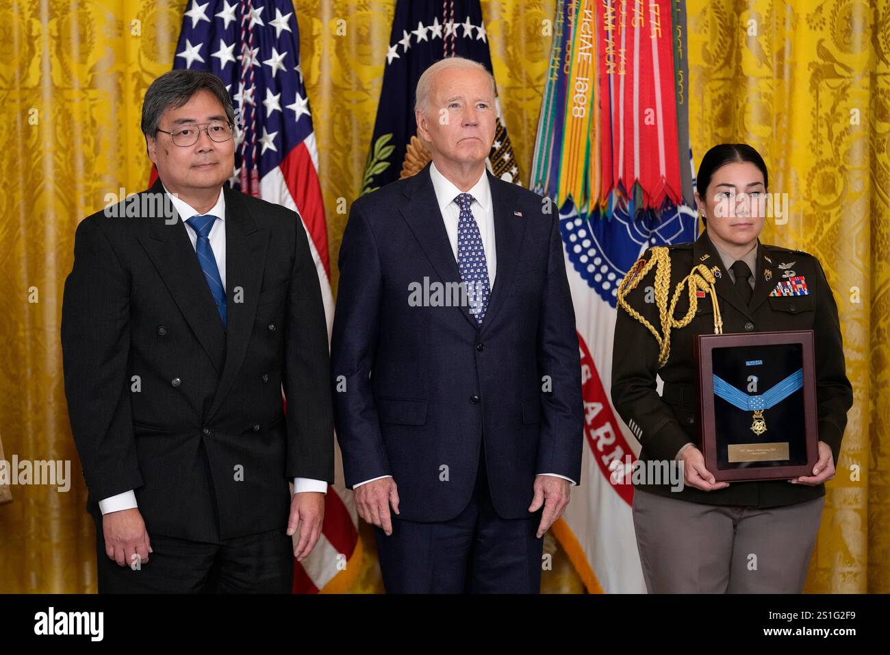 President Joe Biden, center, stands with Gary Takashima, left, before presenting the Medal of ...