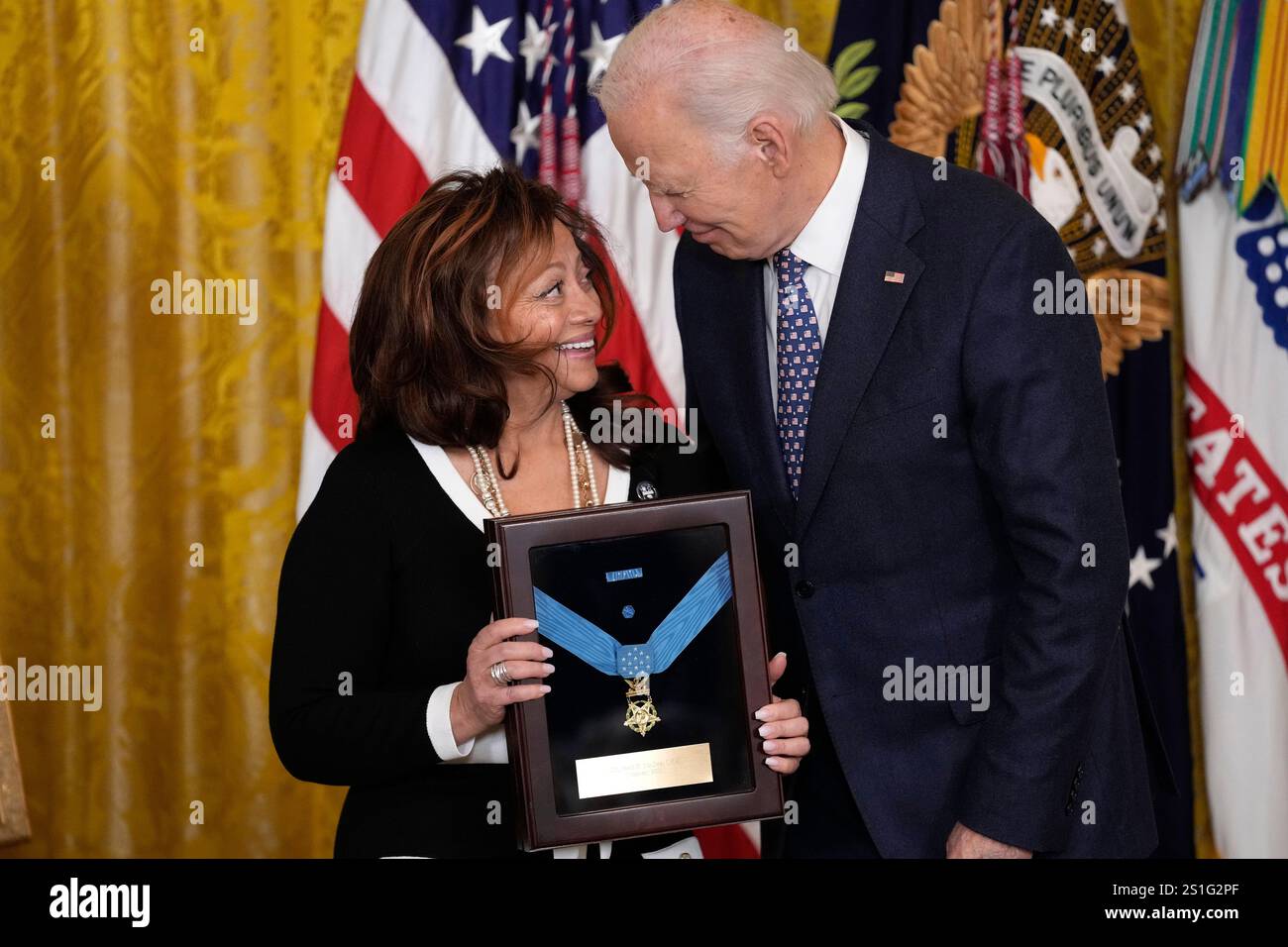 President Joe Biden, talks with Victoria Secrest, as he presents the ...
